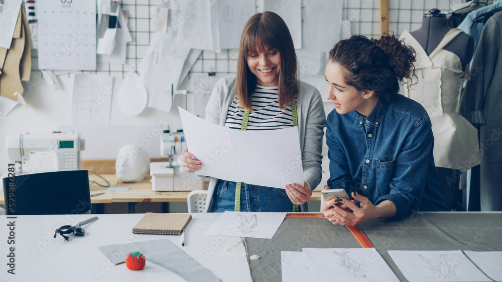 Attractive young women working in design industry are comparing ...