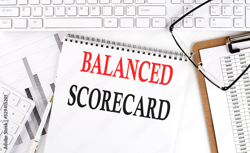 Text BALANCED SCORECARD on Office desk table with keyboard, notepad and ...