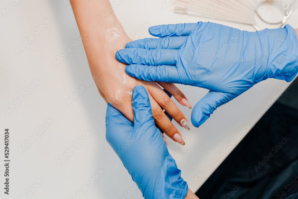 Professional beautician hands in gloves doing hand massage to female ...