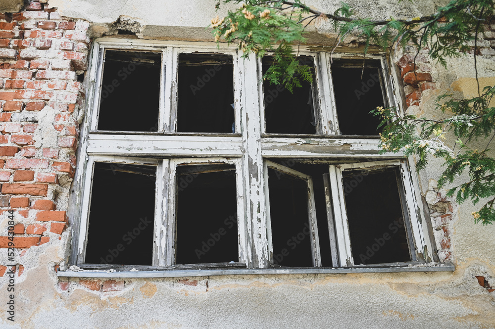 Broken windows on the house. Damaged building as war aftermath. Houses ...