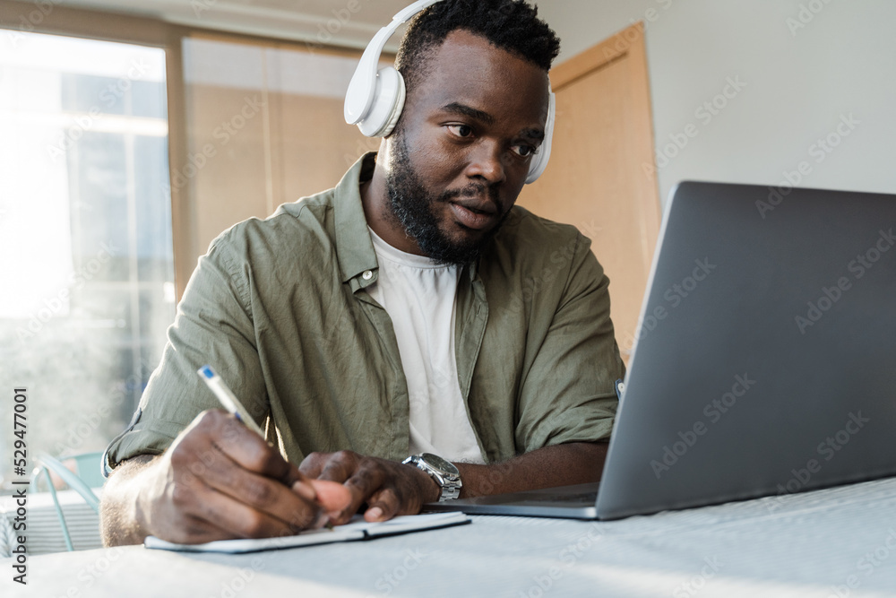 Young african student using computer laptop while studying inside ...