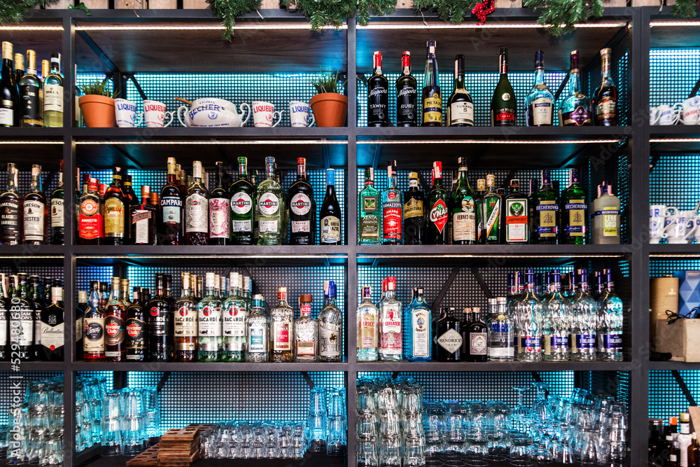 Foto de Backlit bottles and glassware behind a bar also known as the ...