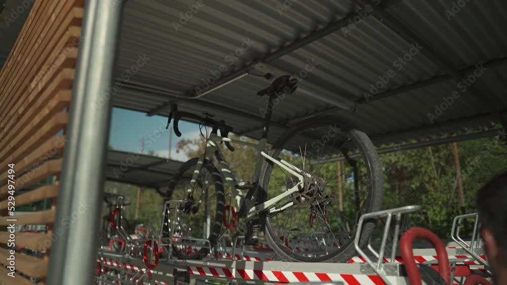Bicycle infrastructure. A man uses double decker bike parking lot in ...