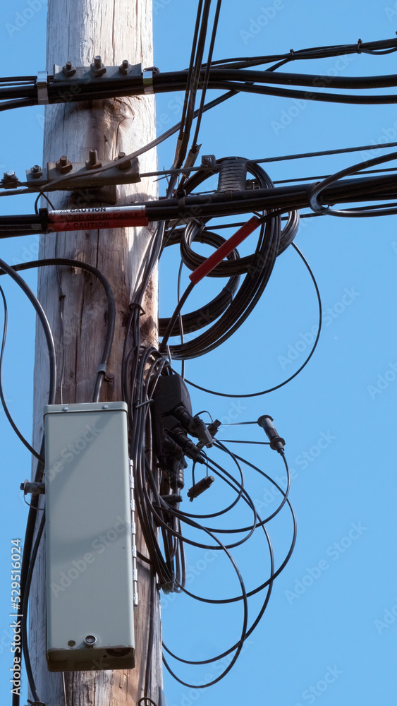 Utility pole with fiber optic cables and junction box, and clear blue ...