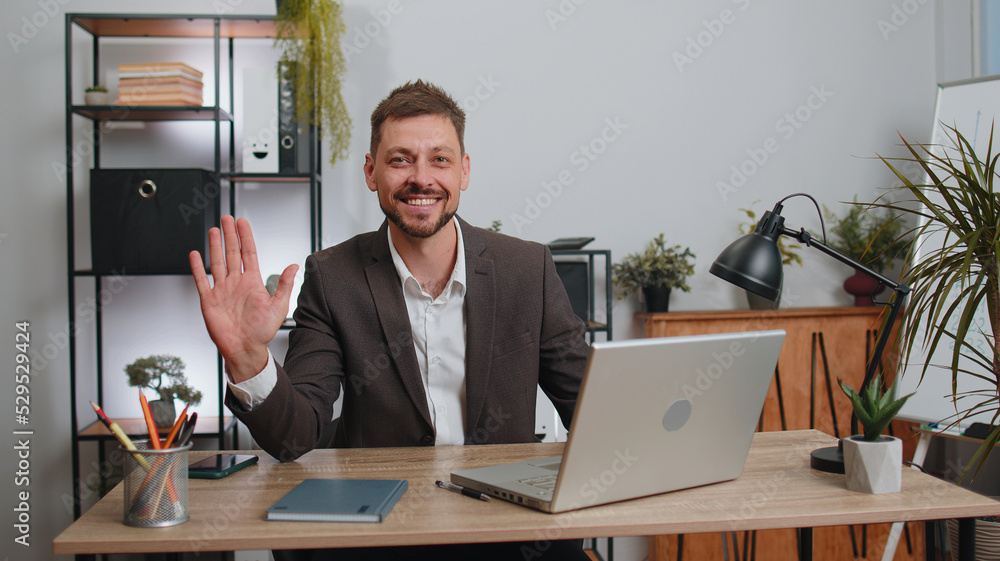 Businessman in suit working on laptop computer smiling friendly at ...