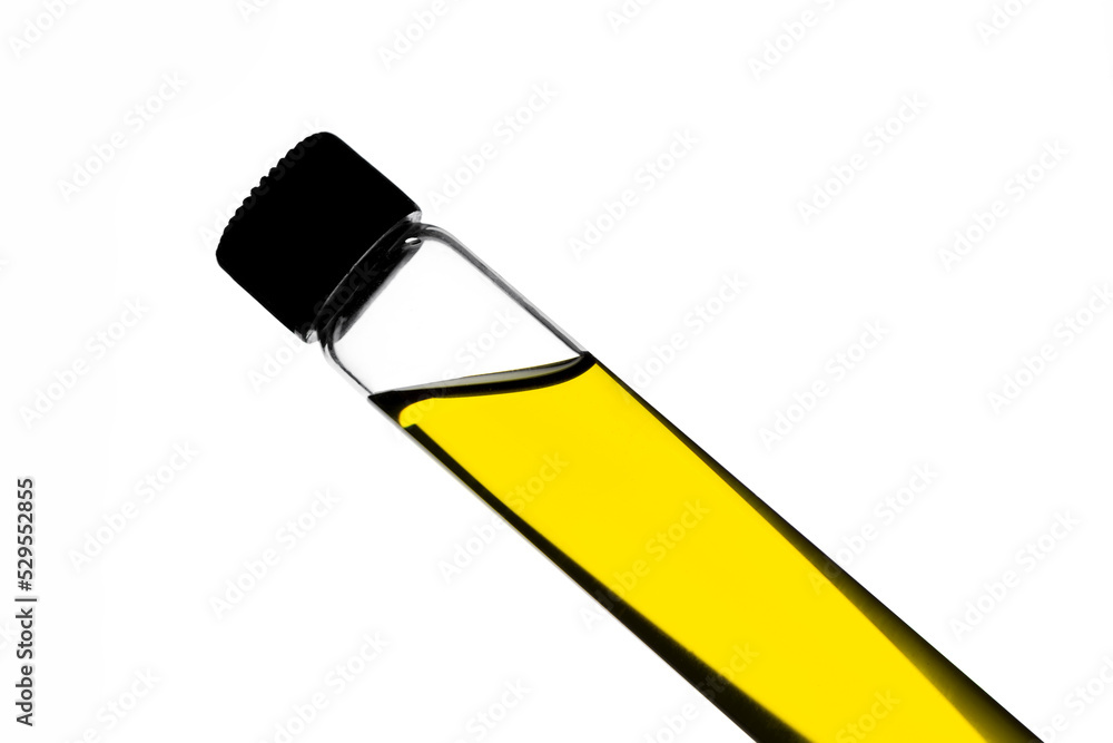 Yellow food coloring added to water in glass test tube with screw cap ...