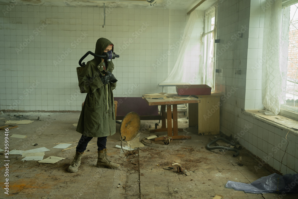 Post-apocalyptic air pollution. Survivor in tatters and gas mask on the ...