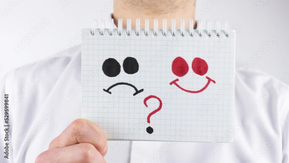A man holds a sad and cheerful emoticon.Sad and funny emoticon and ...
