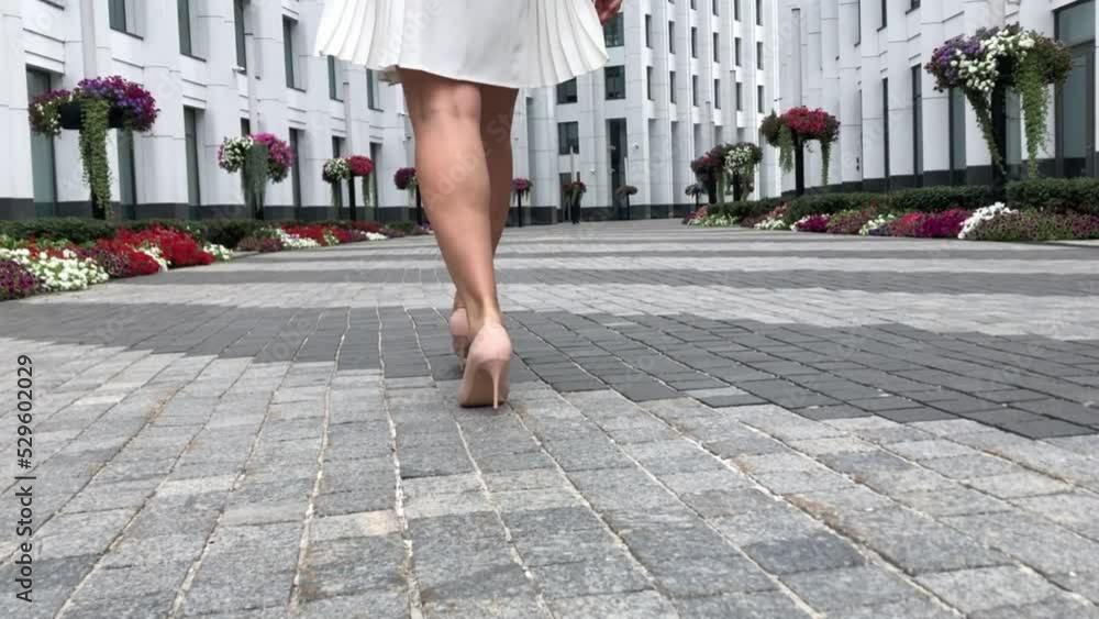 Vidéo Stock Women's legs in beige high-heeled shoes are walking along ...