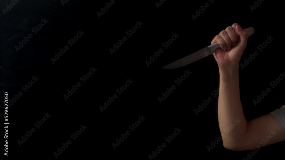 Human hand with knife shot on a black background. Woman's hand holds ...