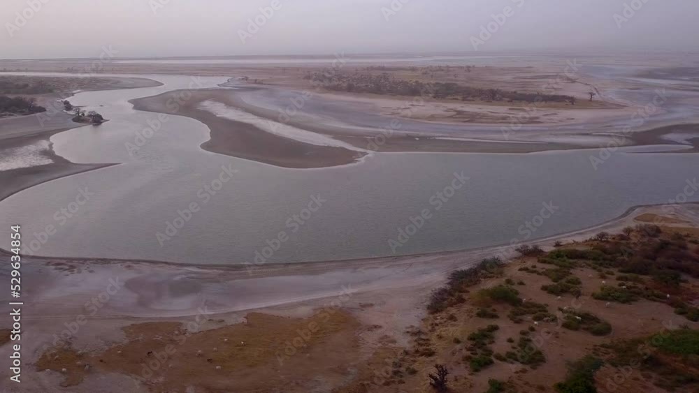 Aerial footage of Saloum river delta with dry land, water ponds, salty ...