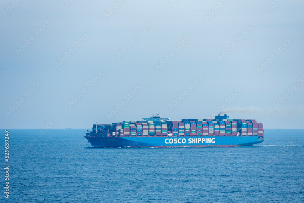 Container ship sailing through the calm sea, she is fully loaded with ...