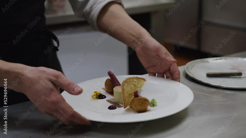 Chefs hands plating and displaying fancy desert in industrial looking ...