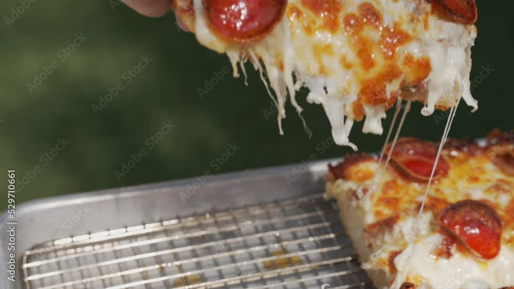 This video shows a deep dish pepperoni pizza with a hand pulling out a ...