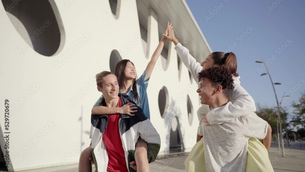 Centennials friends on vacation having piggyback and stacking hands on ...