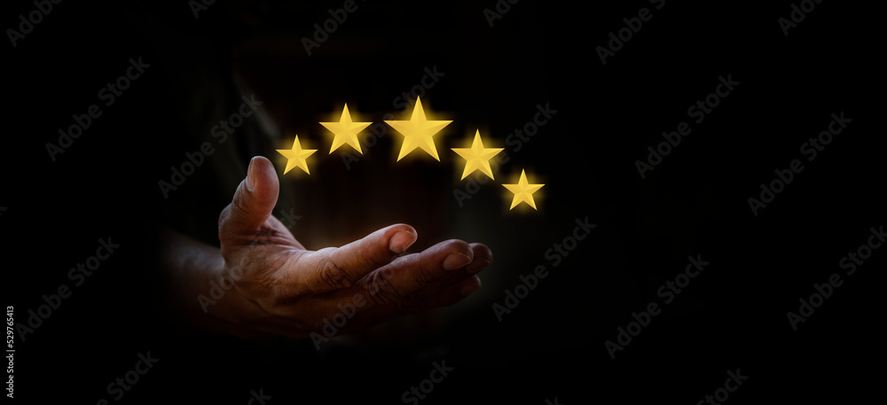 Hand of a man holding five best gold star review scores or satisfaction ...