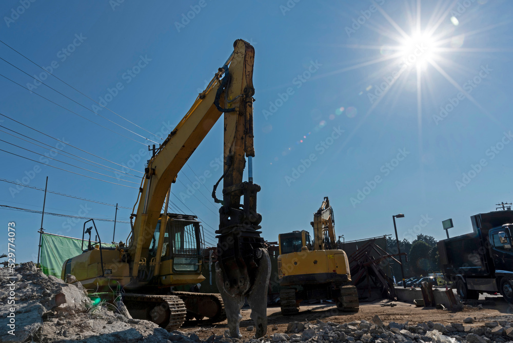 Demolition construction site and silhouette of demolition machine ...