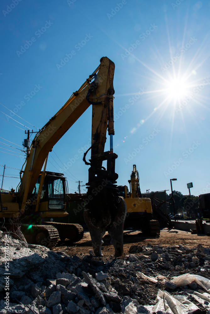 Demolition construction site and silhouette of demolition machine ...