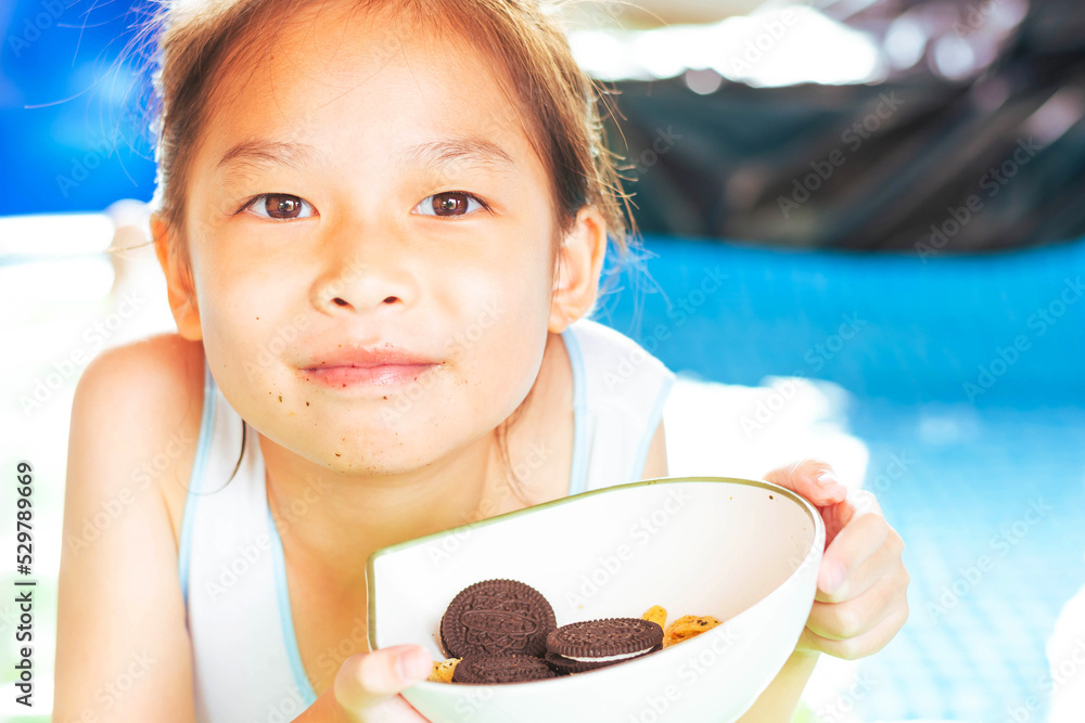 Cute girl eating sweets, sloppy mouth on a rubber raft floating on the ...