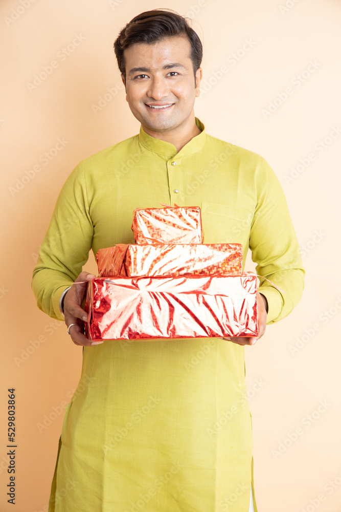 Happy handsome indian man wearing traditional kurta outfit holding red ...