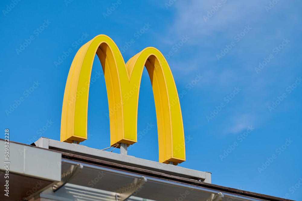 McDonalds logo on roof of fast food restaurant branch, yellow macdonald ...