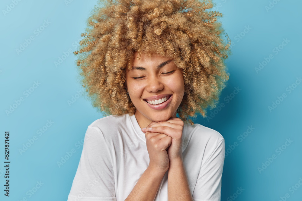 Photo And Art Print Cheerful Curly Haired Woman Keeps Hands Under Chin