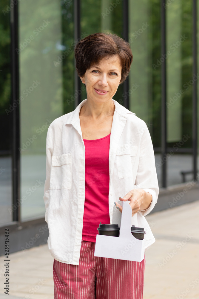 adult Jewish woman middle age holding two black craft paper cups with ...