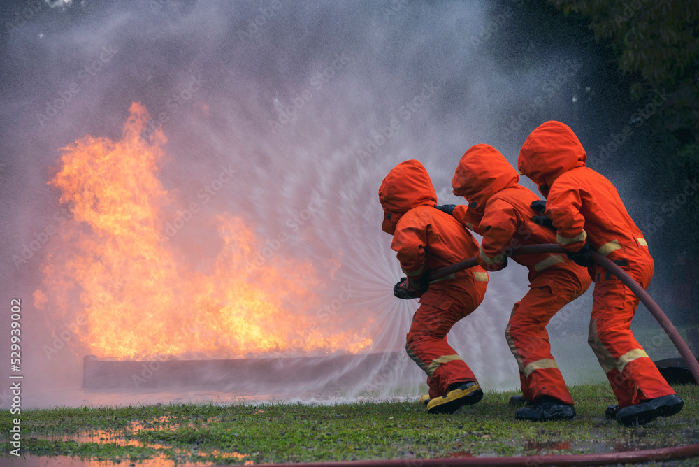 Firefighter fighting with fire flame protection property. Fireman wear ...