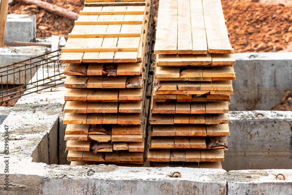 Wooden formwork boards stacked at the construction site. Storage of ...