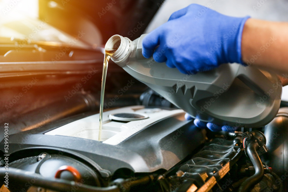 Car oil is pouring into the engine close up. pouring new oil into the ...