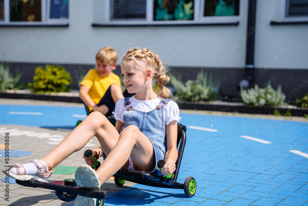 Children compete ride mini bikes on the playground road markings ...