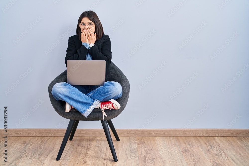 Young hispanic woman sitting on chair using computer laptop laughing ...