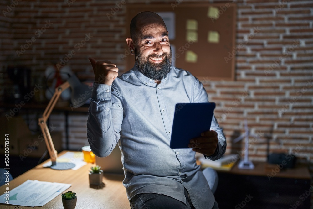 Young hispanic man with beard and tattoos working at the office at ...