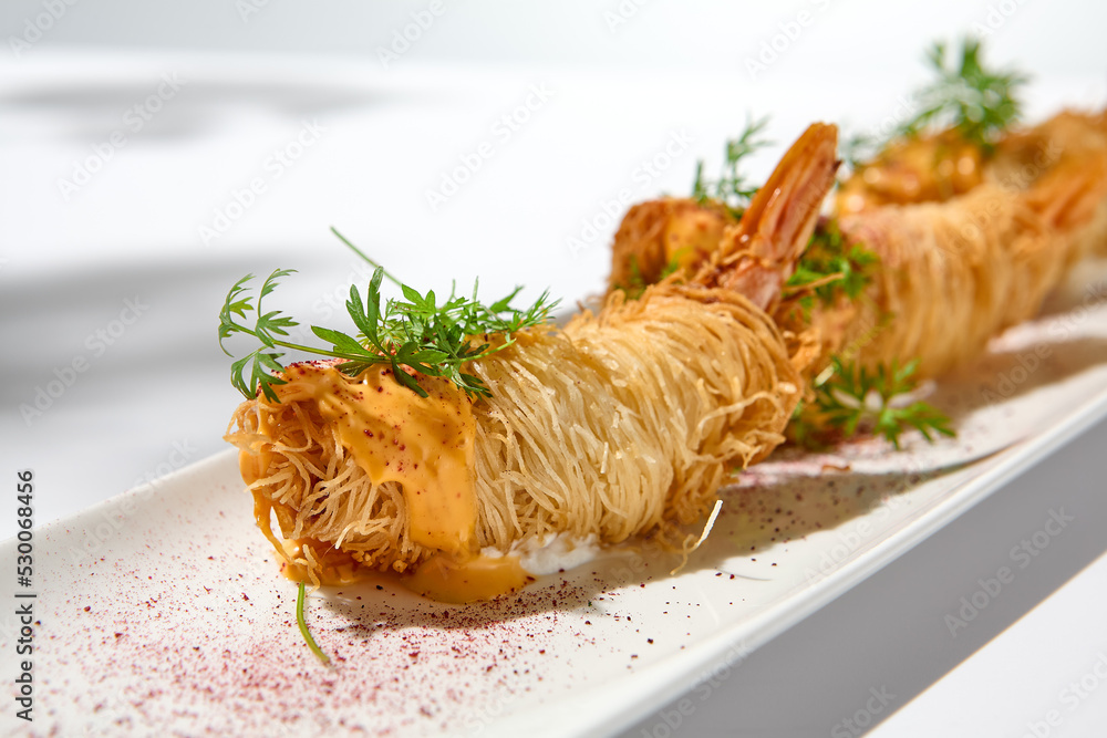 Foto de Traditional greek appetizer - kataifi wrapped shrimps on white ...