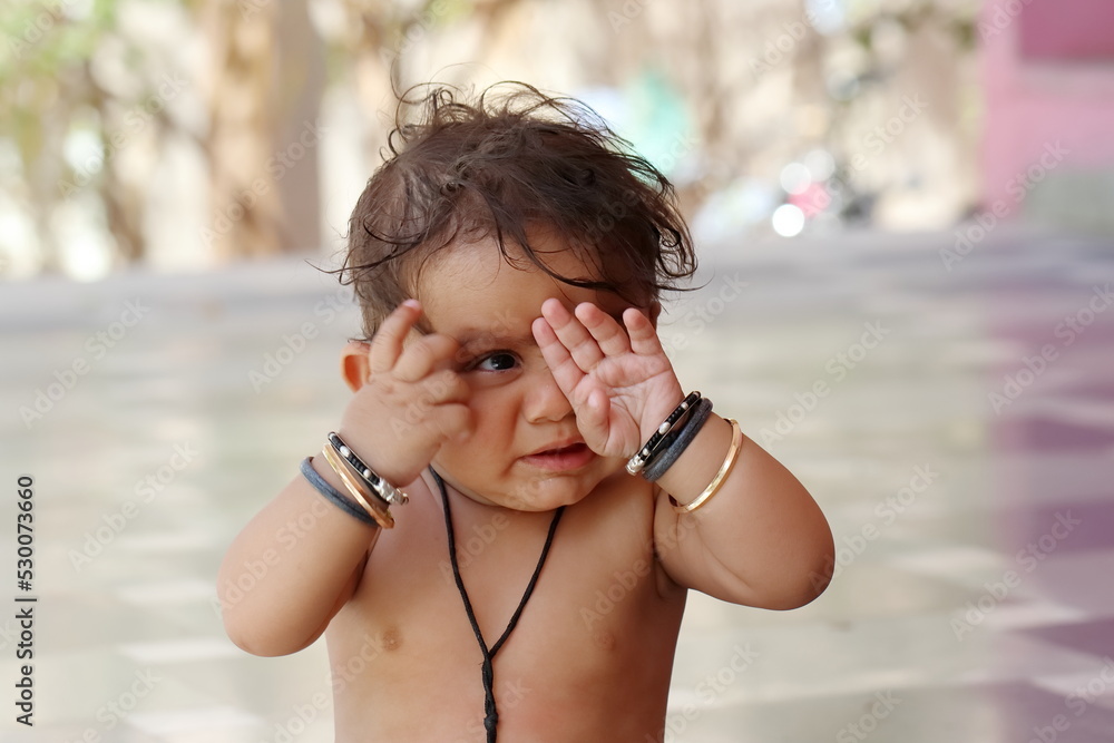 Adorable Little child covering his one eye with his hands and without ...