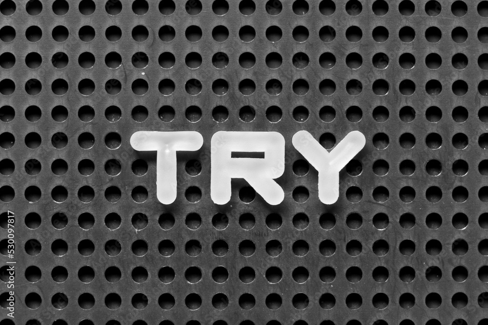 White alphabet letter in word try on black pegboard background Stock ...