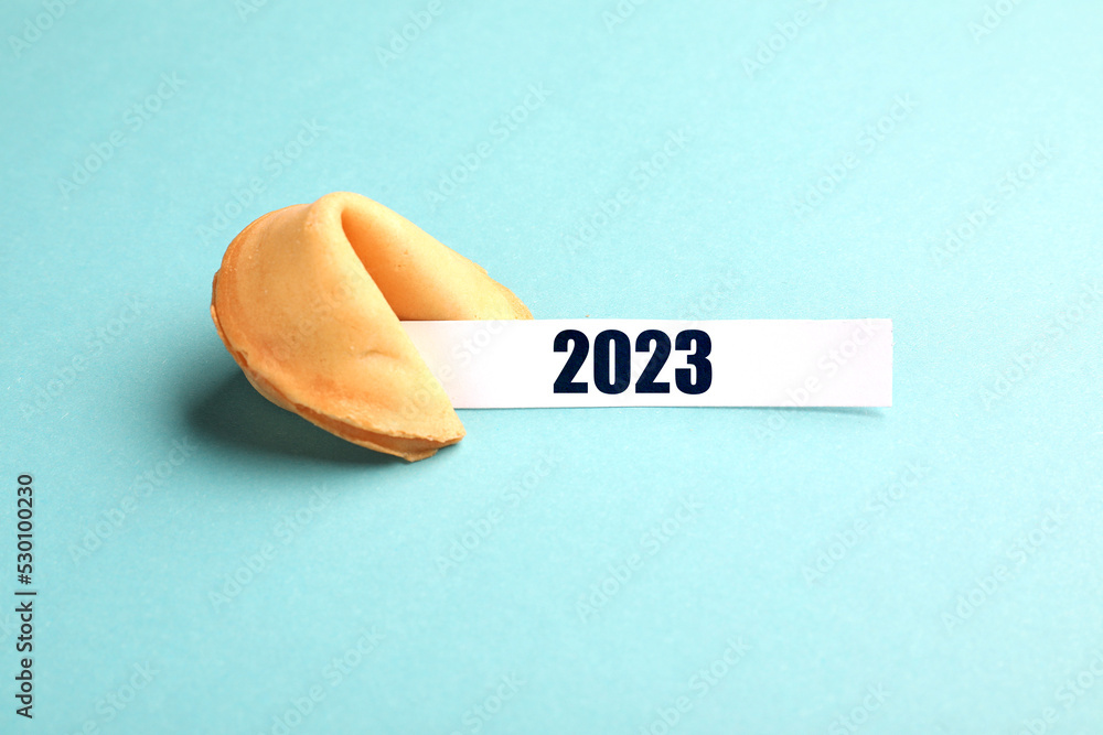 Tasty fortune cookie and paper with number 2023 on light blue ...