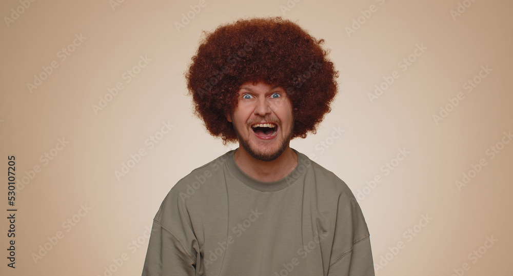 Joyful man with lush hairstyle laughing out loud after hearing ...