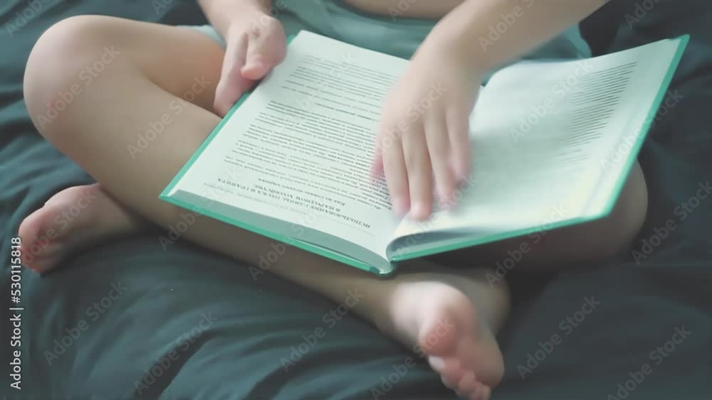 The child leafs through the book. A little boy flips through the pages ...