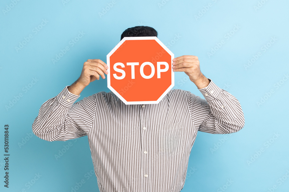 Portrait of man covering face with Stop symbol, anonymous person ...