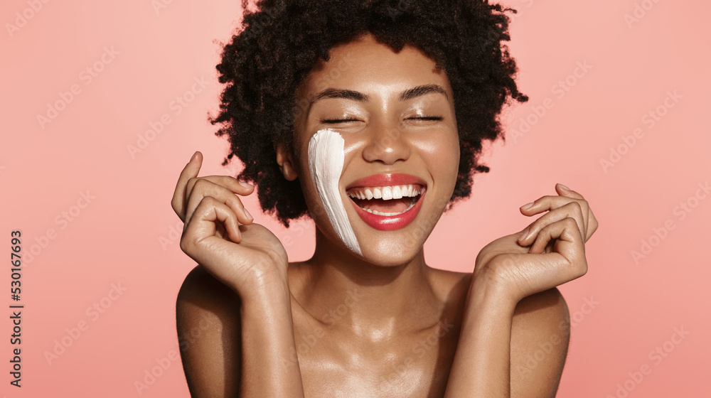 Foto de Happy woman washing her face with cleansing foam, hydrating her ...