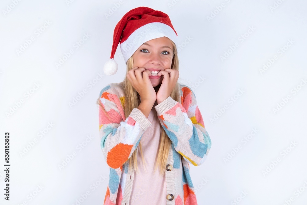 Fearful little kid girl with Christmas hat wearing yarn jacket over ...
