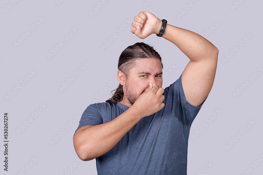 A man covers his nose in disgust from the bad smell emanating from his ...