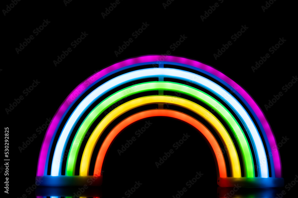 Image of vibrant neon glow sticks forming rainbow over black background ...