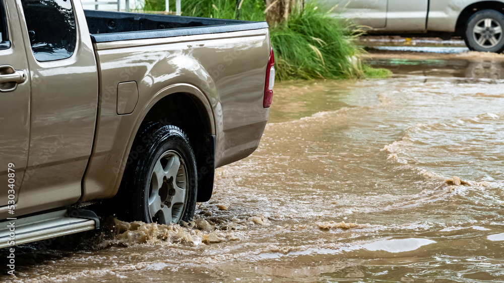 Pickup truck passing through flooded road. Driving car on flooded road ...