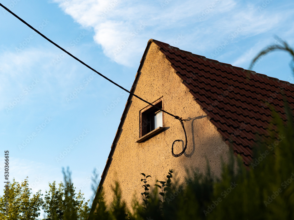 Residential building with a cable on the exterior wall. Gable roof with ...