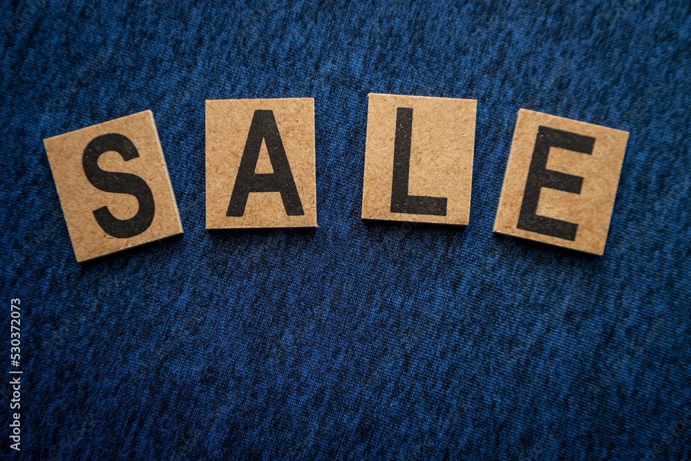 Sign with the word "SALE" formed with letters of wooden squares on a ...