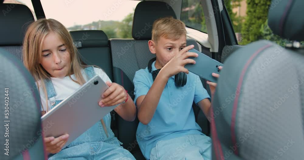 Beautiful children boy and girl having fun playing games on phone and ...