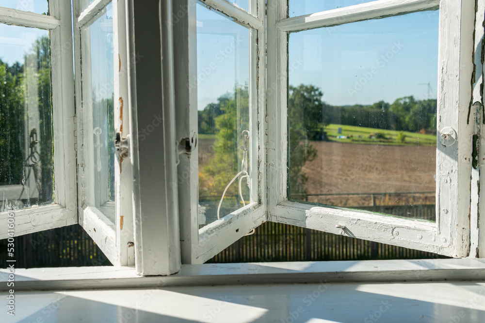 View from open window in the village. White old wooden windows with ...