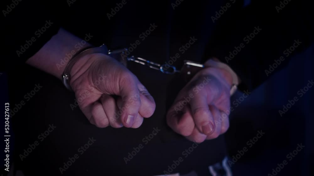 Arrested man in handcuffs. Handcuffed hands behind his back and ...